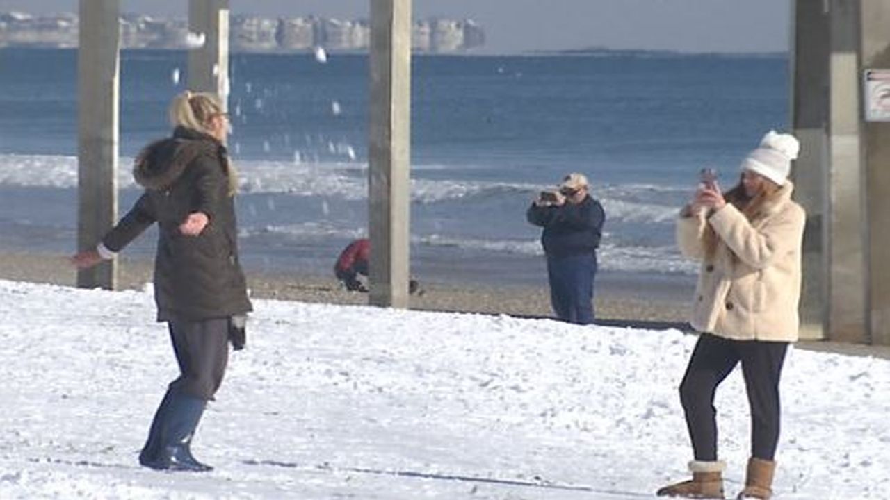 Rare snow on the coast brings beachgoers