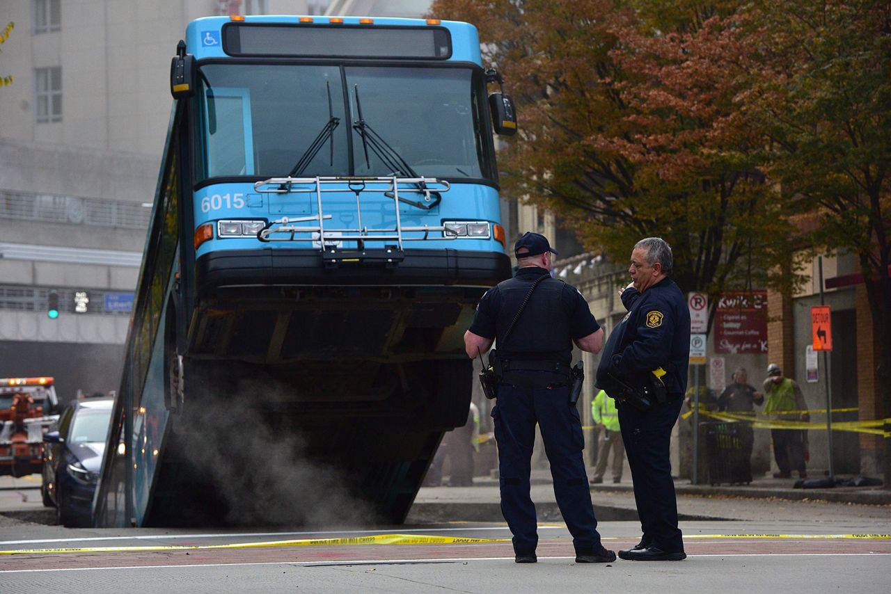 Sinkhole opens, swallows part of city bus during rush hour