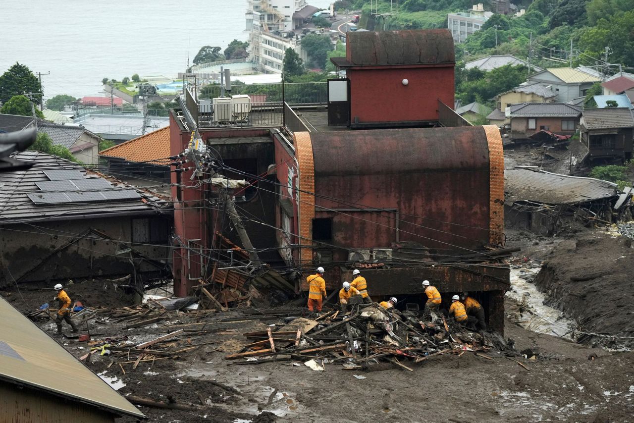 Rescuers slog through mud in Japan resort where 20 missing