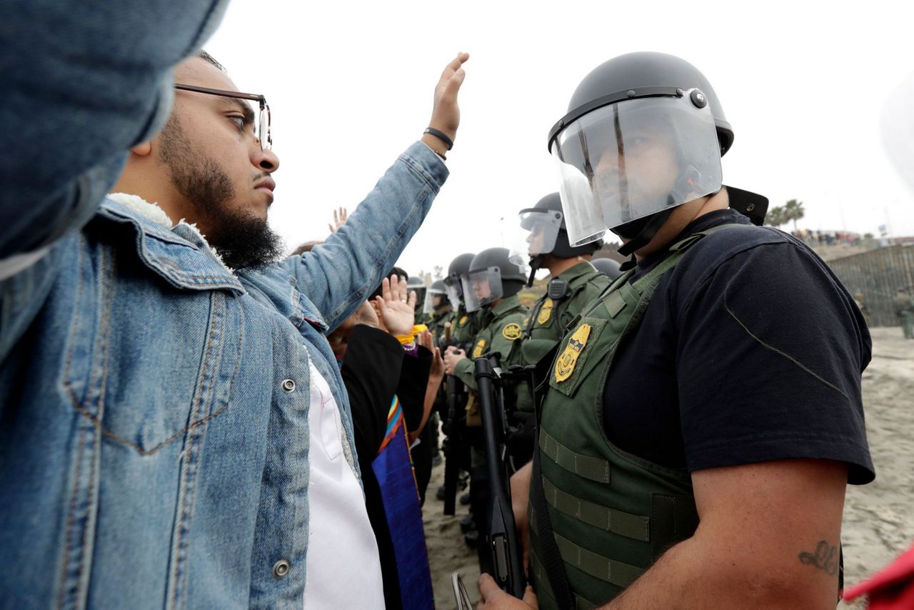 Border Patrol handcuffs demonstrators supporting migrants