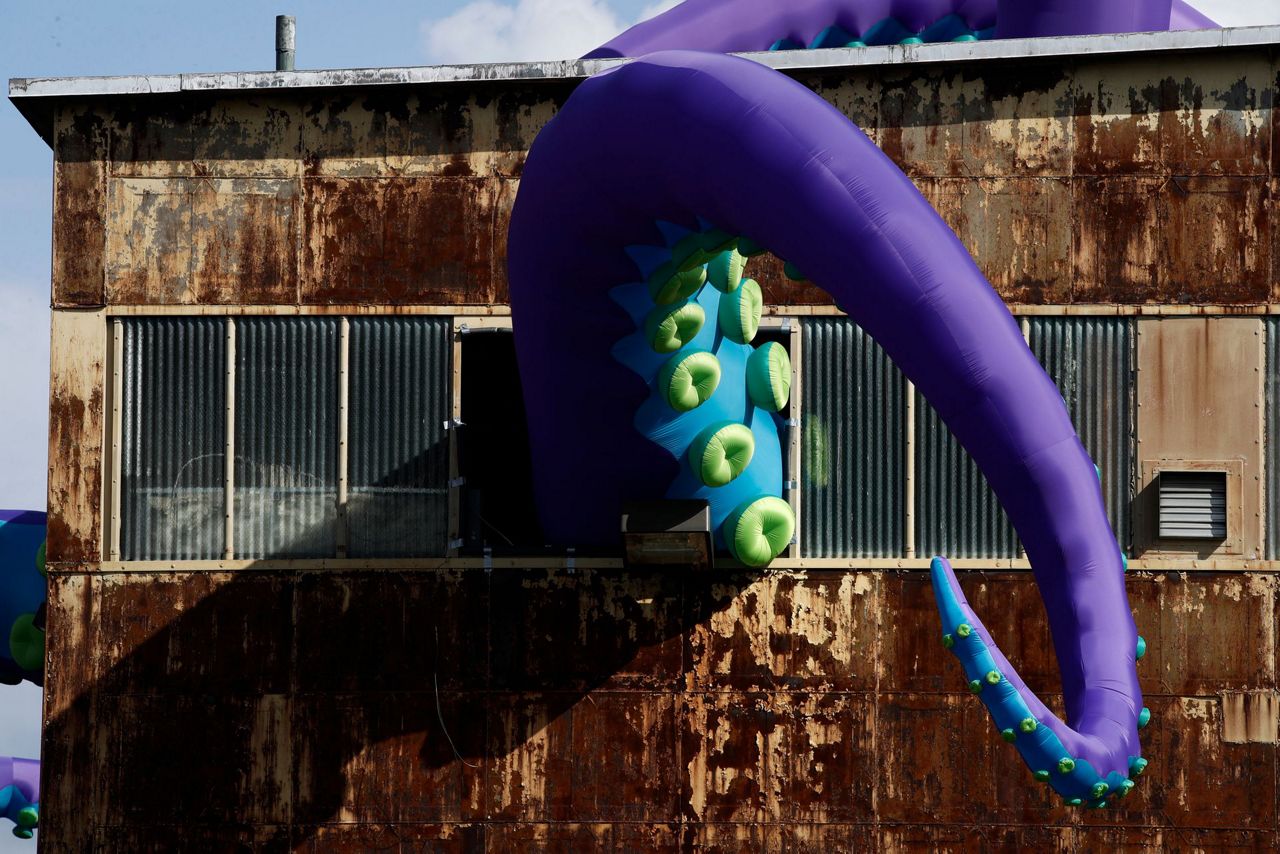 Inflatable sea monster takes over a rusting warehouse