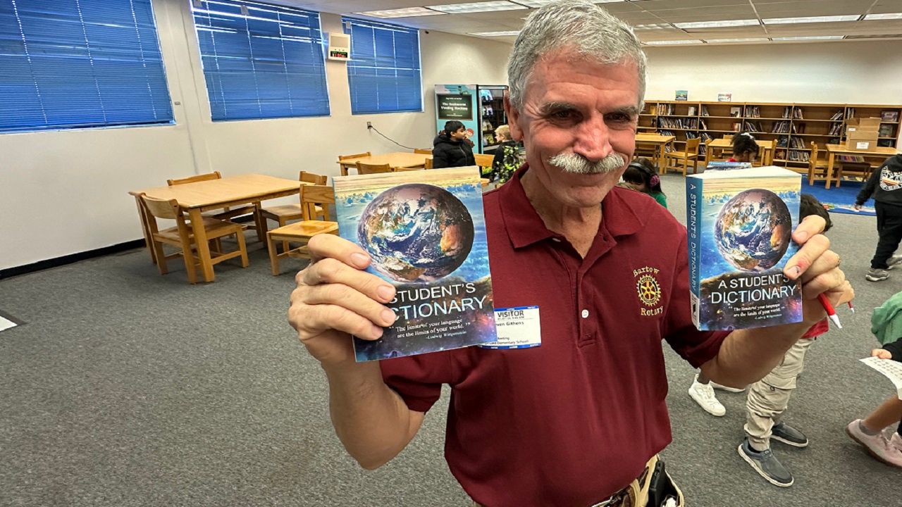 Steve Githens gives dictionaries to third graders in Polk