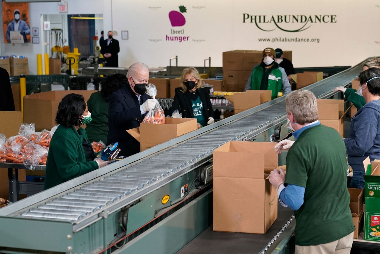 Bidens pack carrots, apples into boxes during food bank stop