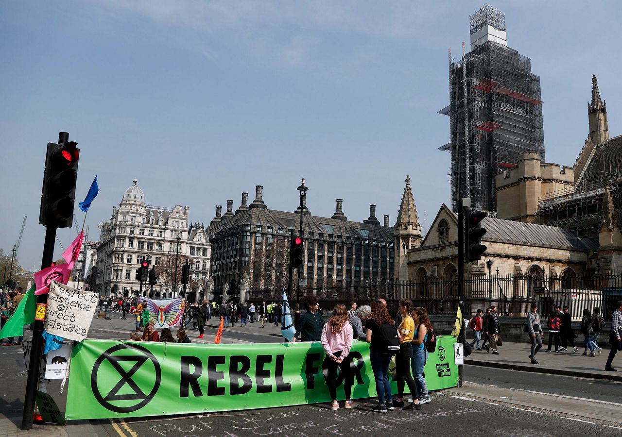 UK climate protesters block roads, glue themselves to train
