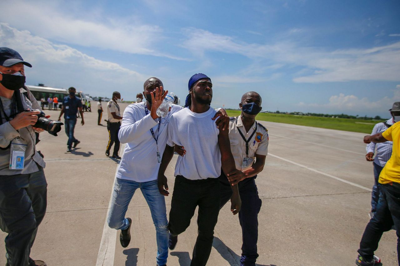 Deported Haitians try to rush back into plane amid anger