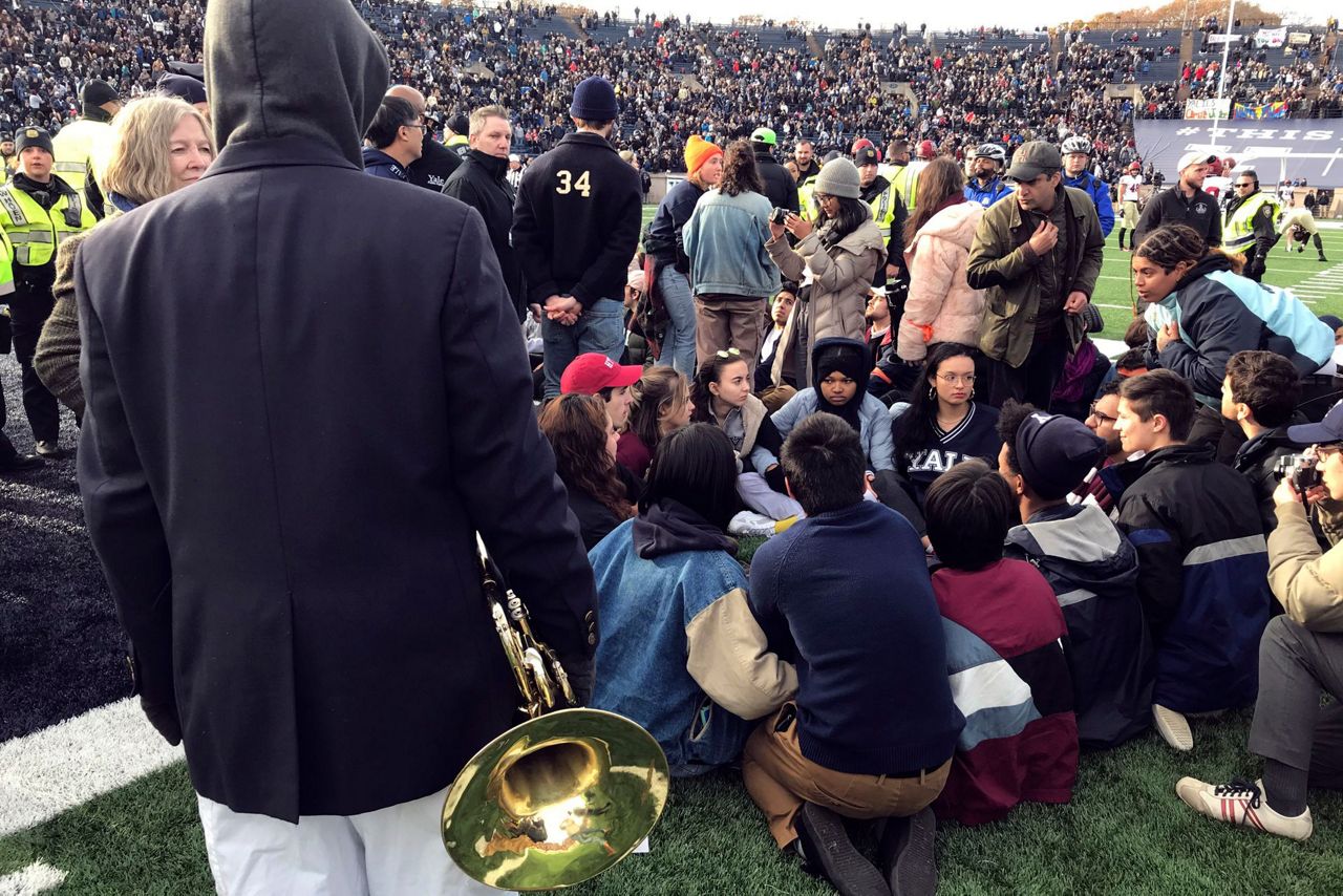 Students storm field at halftime of Harvard-Yale to protest