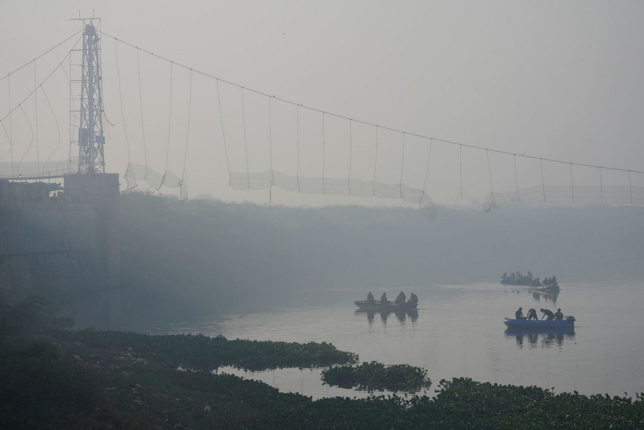Officials probe India bridge collapse as divers comb river