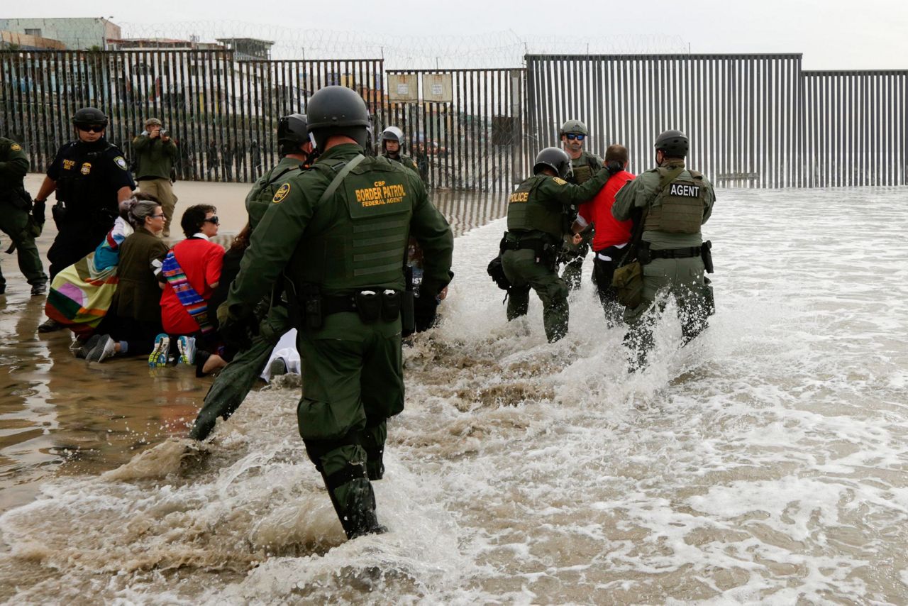 Border Patrol handcuffs demonstrators supporting migrants