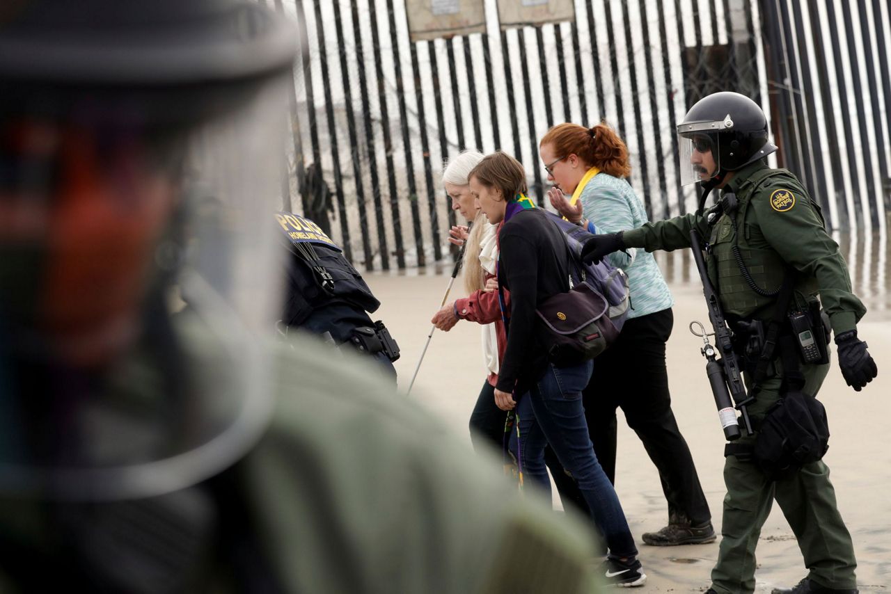 Border Patrol handcuffs demonstrators supporting migrants