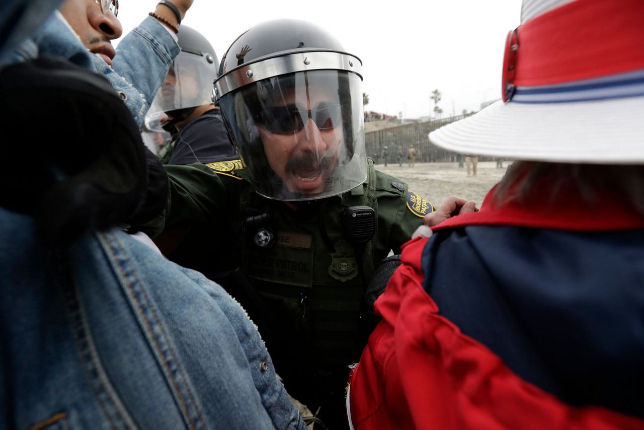 Border Patrol handcuffs demonstrators supporting migrants