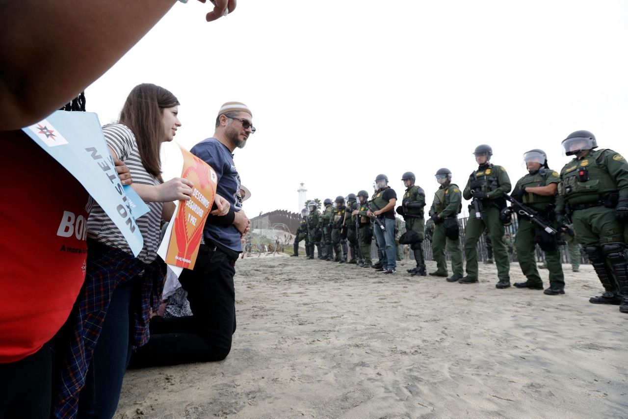 Border Patrol handcuffs demonstrators supporting migrants