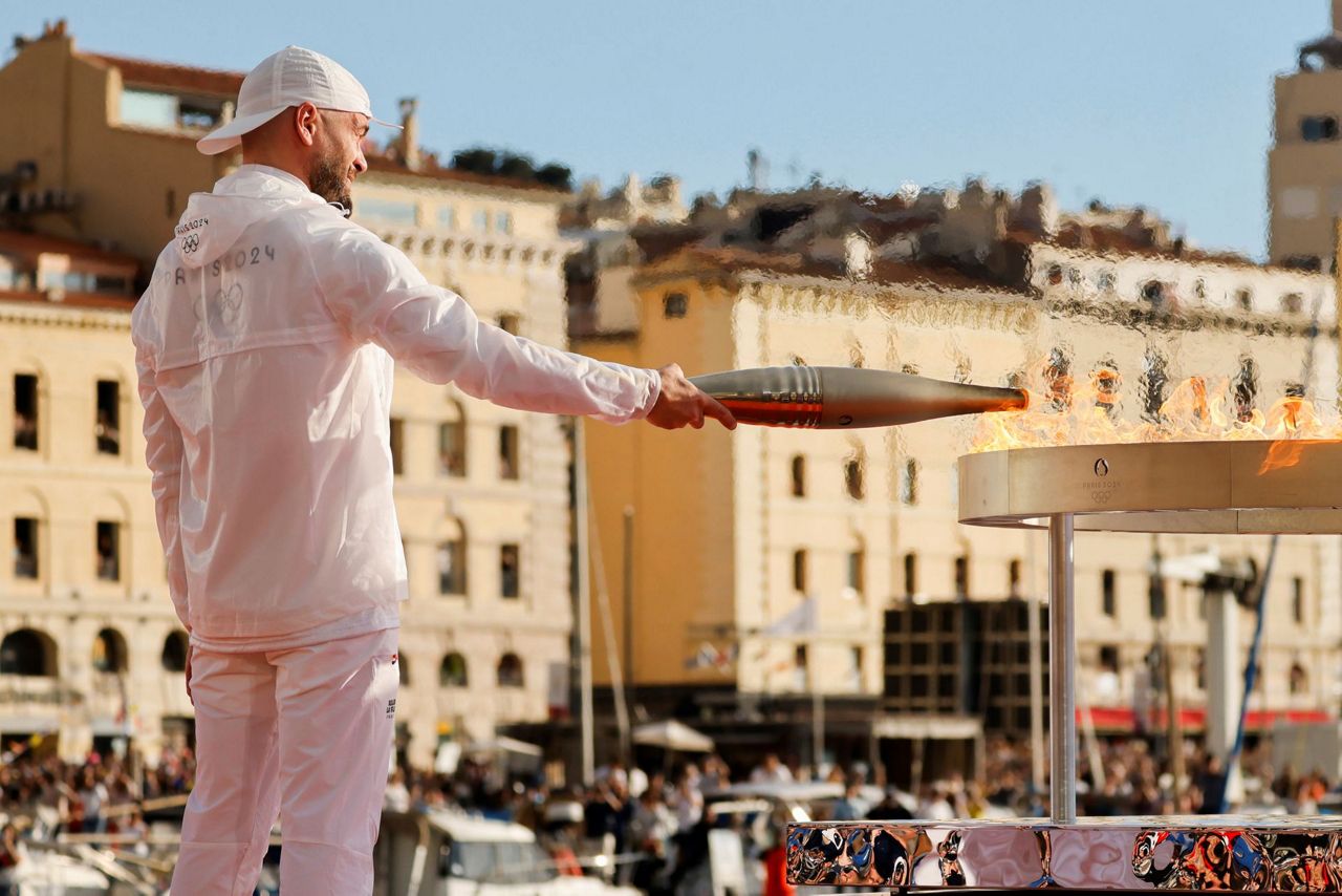 A ship carrying the Olympic torch arrives in Marseille amid fanfare and ...