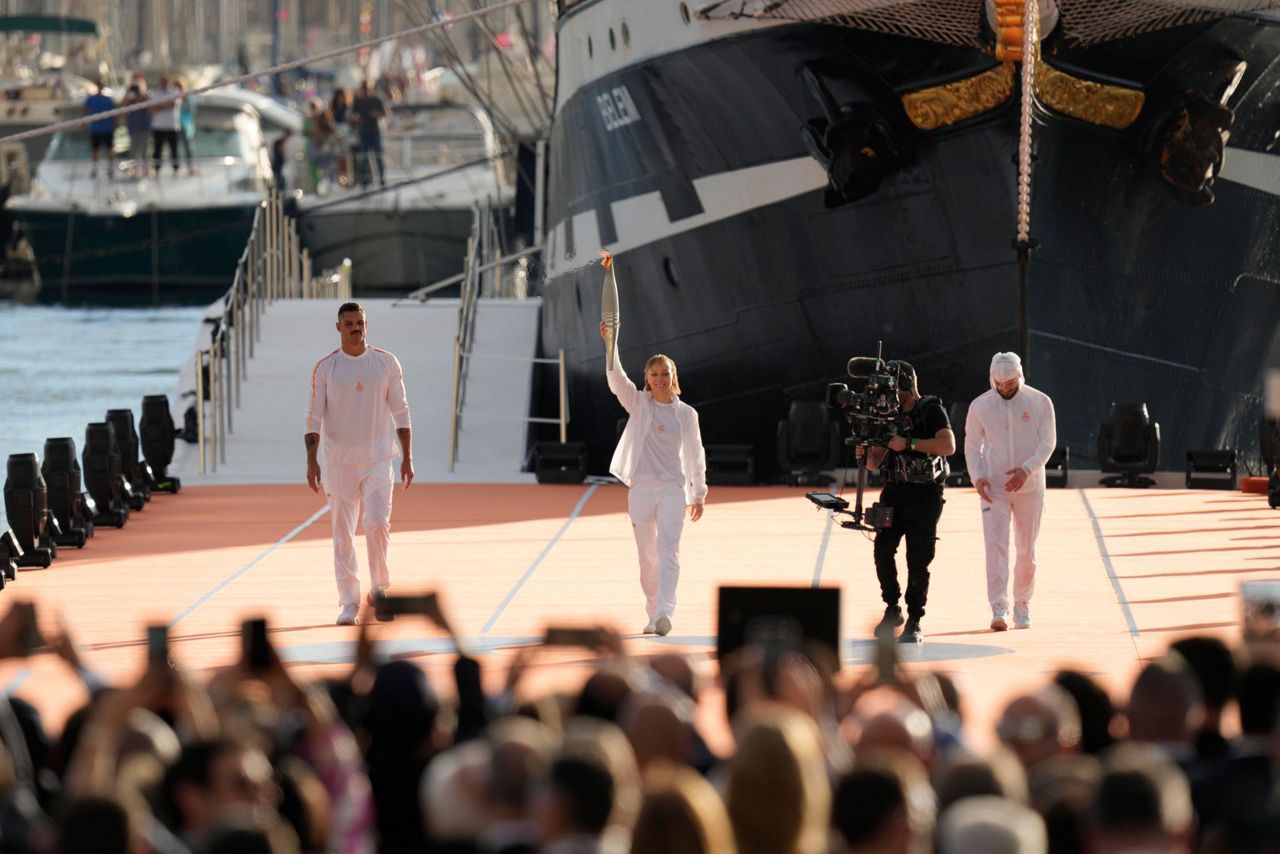 A ship carrying the Olympic torch arrives in Marseille amid fanfare and ...