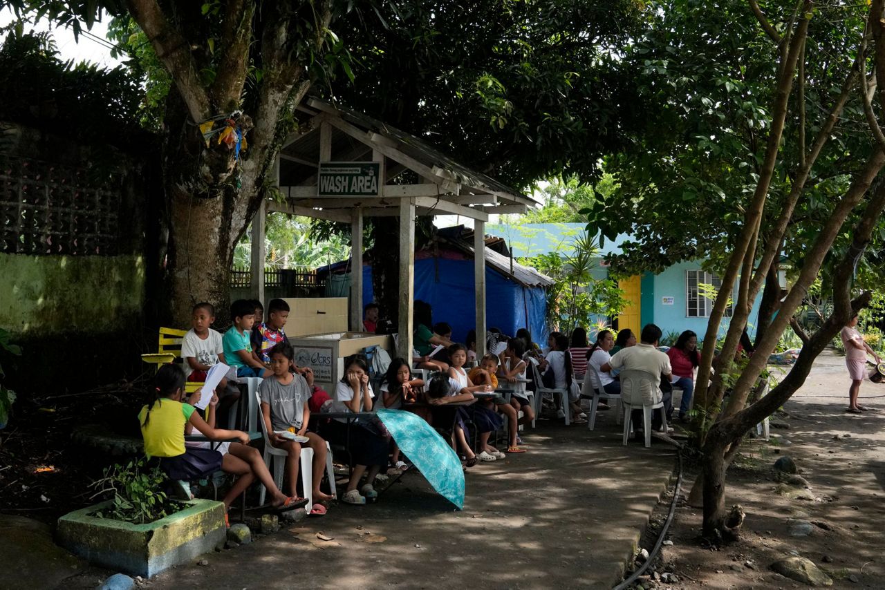 Students meet under trees as schools shelter villagers displaced by ...