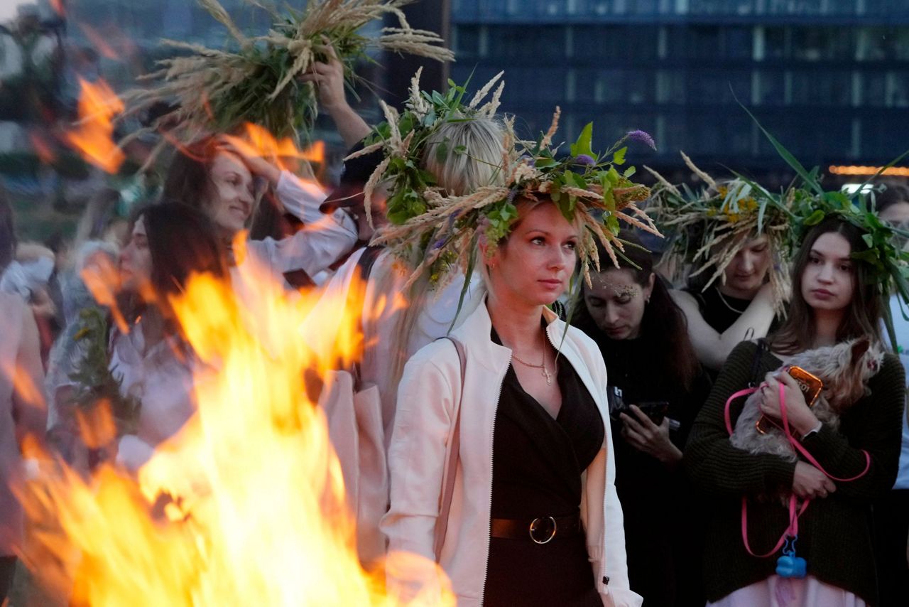 Ukrainians in Warsaw jump over a bonfire, float braids to celebrate ...