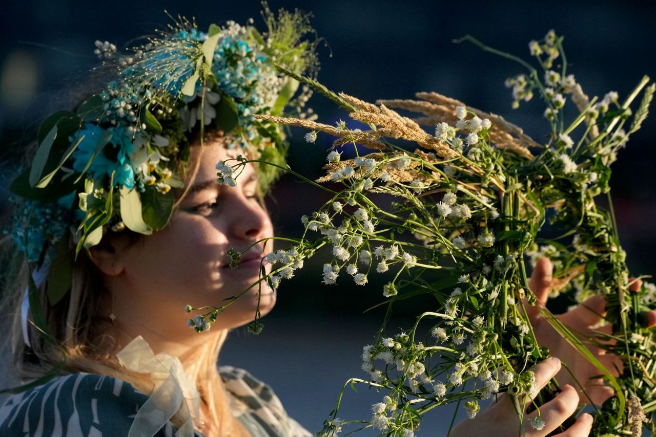 Ukrainians in Warsaw jump over a bonfire, float braids to celebrate ...