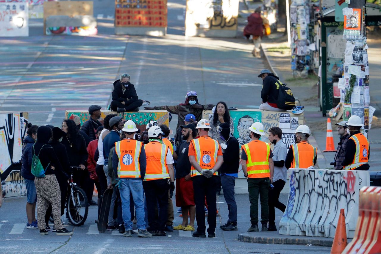 Demonstrators resist as crews arrive at Seattle protest zone