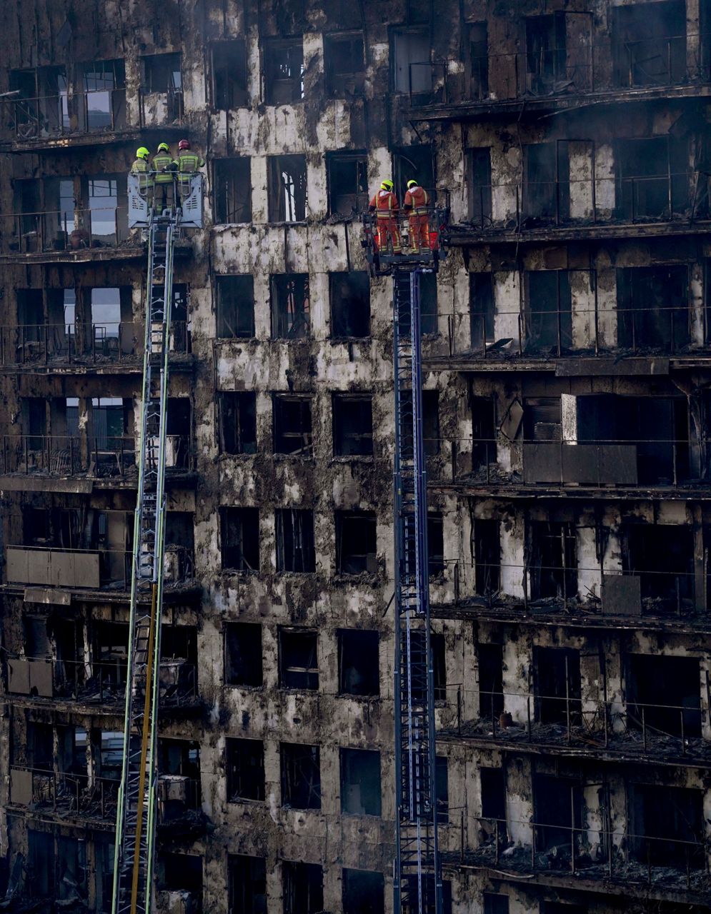Rescuers search for 14 people missing after apartment block fire in ...