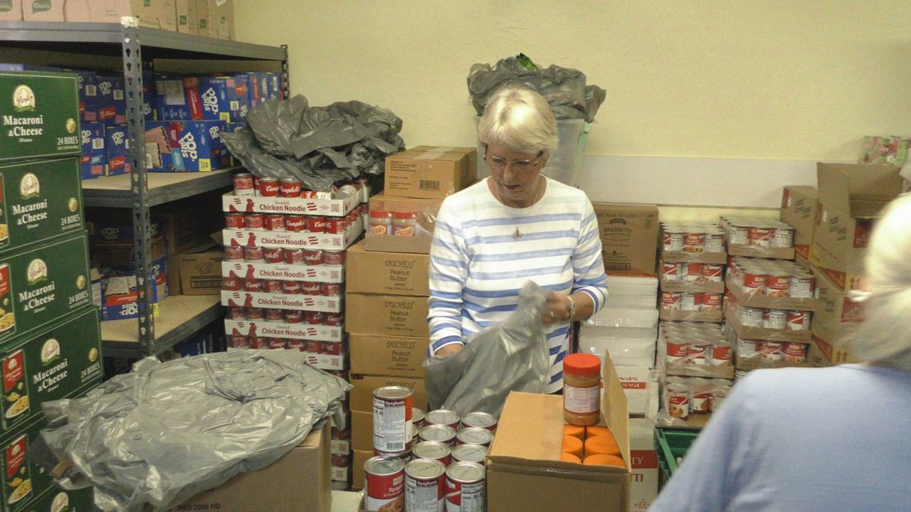 Volunteers pack food bags for children in need