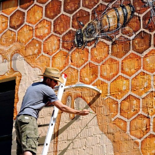 Muralist paints bee mural in Hendersonville