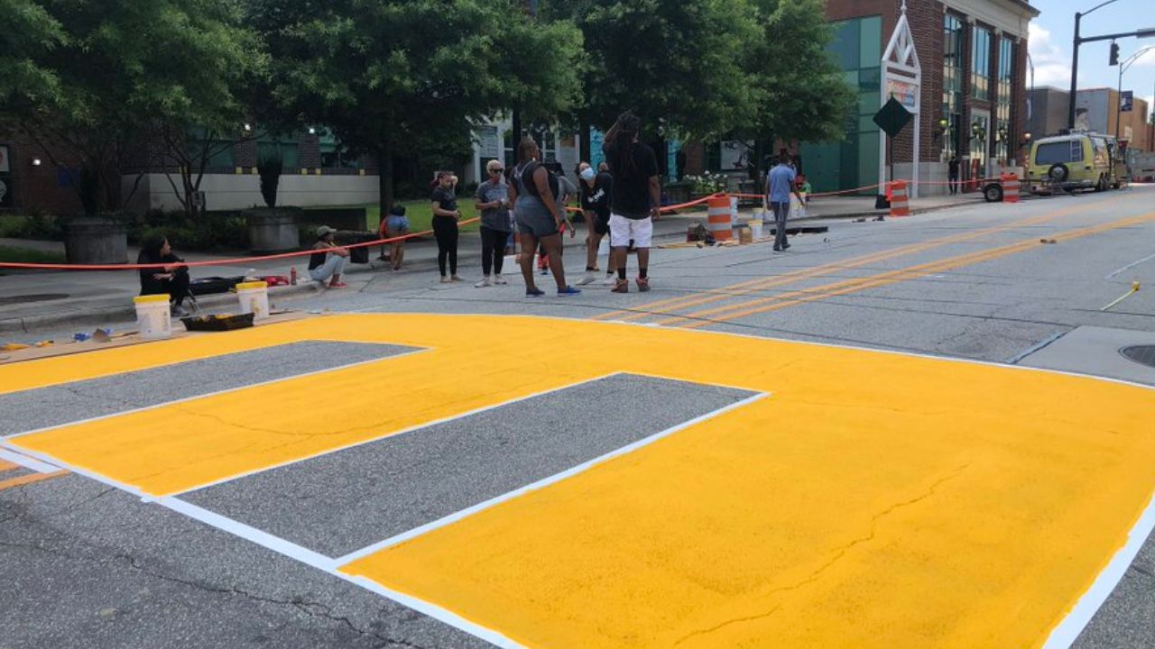 Artists Create "One Love" Street Mural In Downtown Greensboro